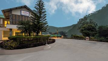 Um hotel chamado 'Sleking Corbett' com design arquitetônico moderno, área de jardim ajardinada e um cenário montanhoso.