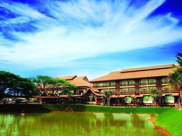 Hotel com vários edifícios, um lago e vegetação ao redor.