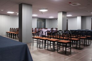 Uma sala de conferências com uma mesa comprida e várias cadeiras dispostas ao redor.