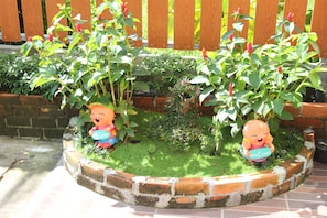Um canteiro com plantas e duas figuras de personagens de desenho animado.