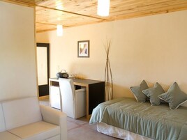 Quarto com cama, escrivaninha e cadeira.