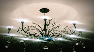 Um candelabro com várias luminárias e detalhes em cristal.