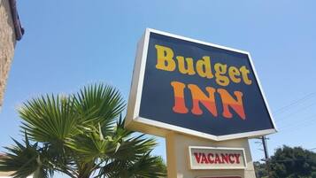 Placa da Budget Inn com a palavra 'VACÂNCIA' escrita abaixo.