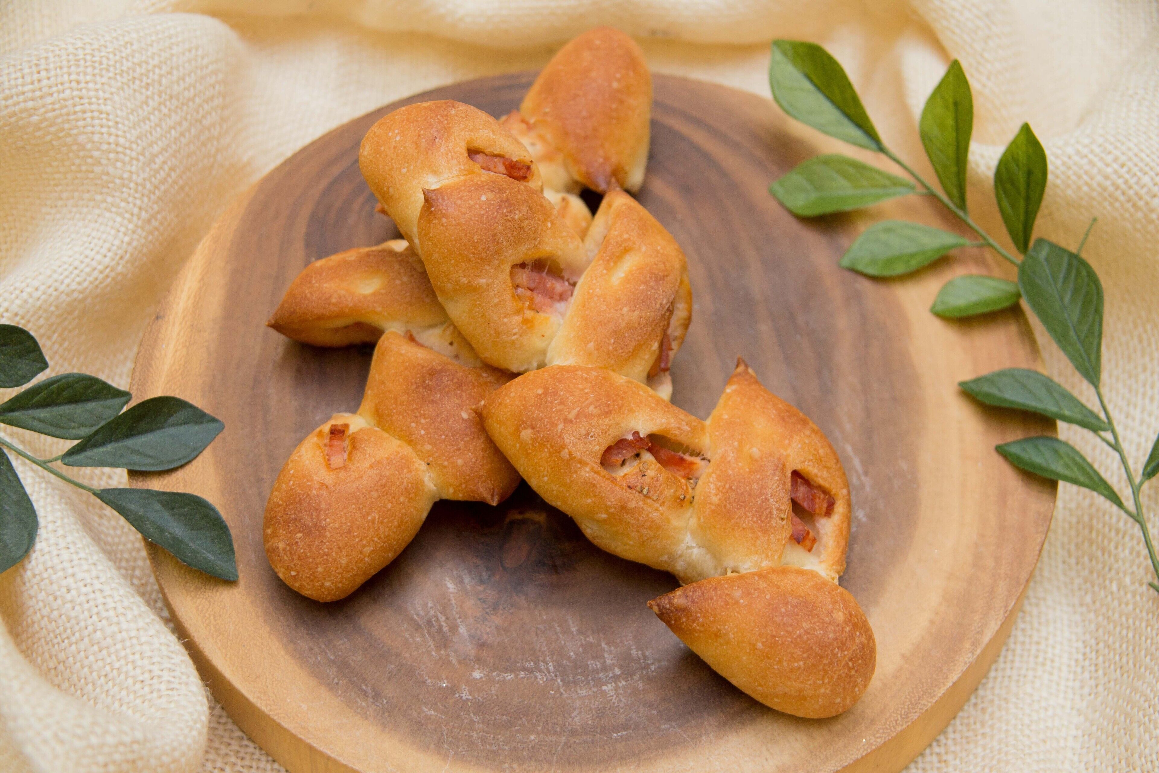 Uma tábua de madeira com doces dourados sobre um tecido texturizado.
