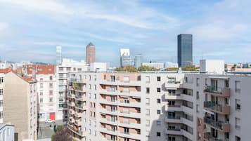 Um edifício residencial alto com várias varandas e vista para o horizonte da cidade.