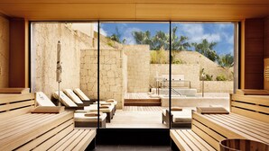 Uma sauna com bancos de madeira e parede de pedra.