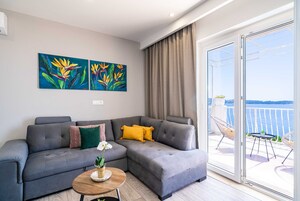 Apartamento Superior, 1 quarto, varanda, vista para o mar | Sala de estar | Televisor de ecrã plano de 40 polegadas com canais por cabo, televisor 