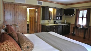 Quarto com cama grande, guarda-roupa de madeira e televisão no quarto vizinho.