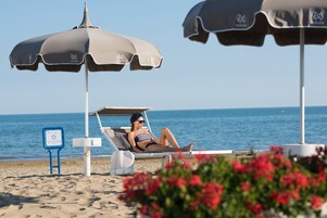 Uma praia privada, espreguiçadeiras, guarda-sóis de praia 