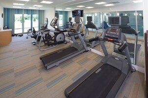 Academia com esteiras, bicicletas ergométricas e área de musculação.