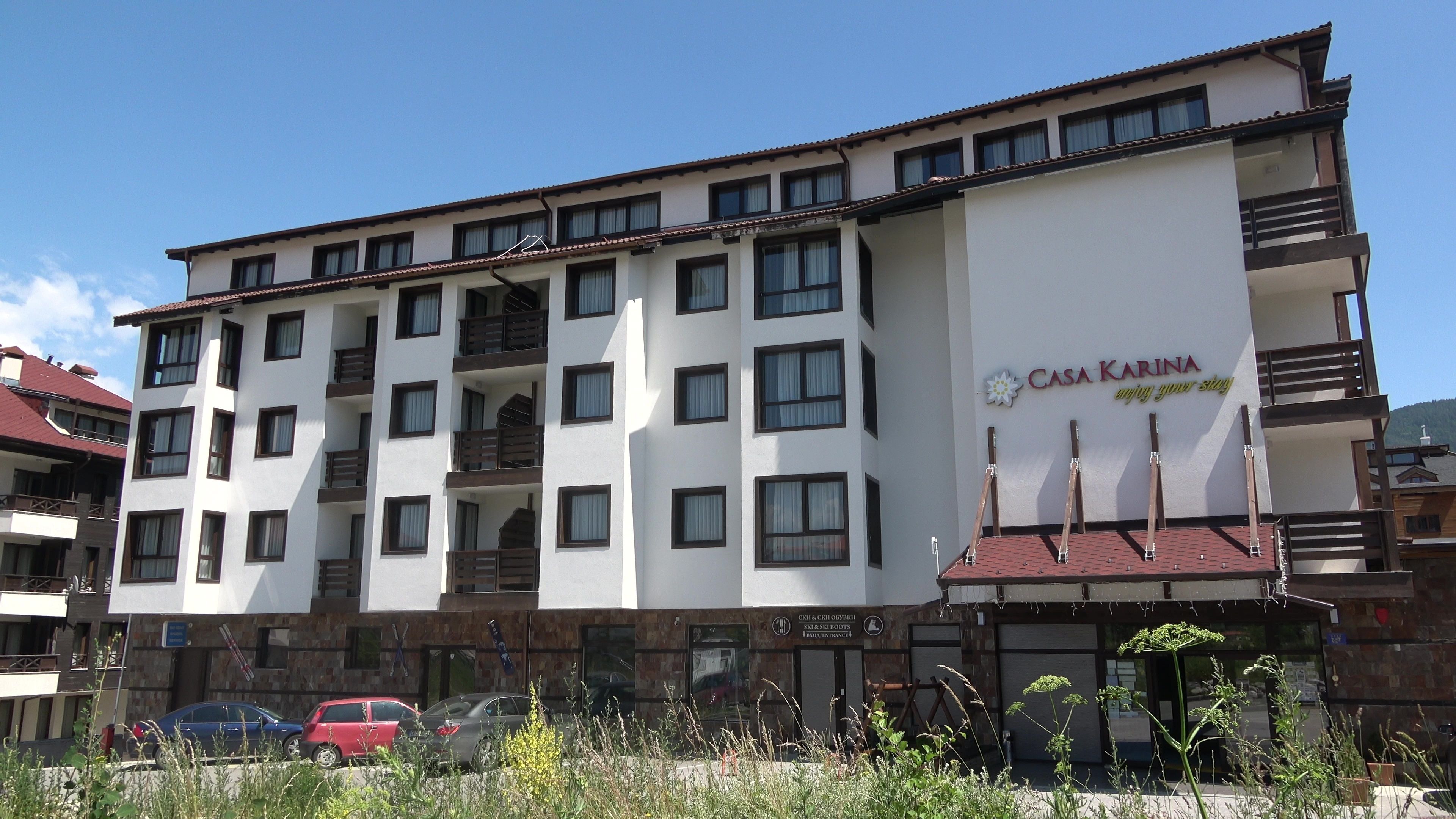 Um hotel com vários andares, fachada branca e varandas.