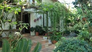 Um jardim com vasos de plantas e uma cerca de madeira.