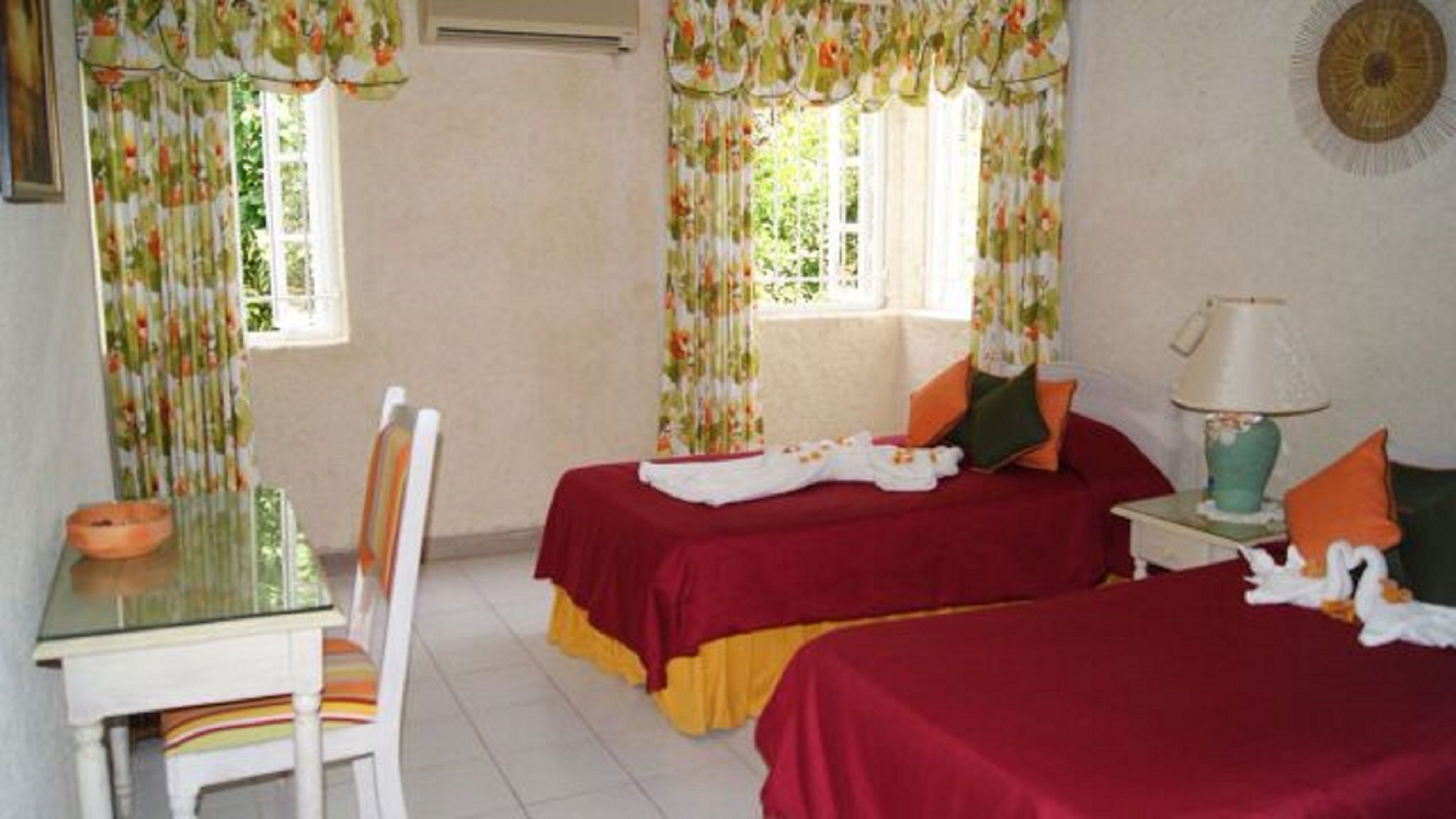 Quarto com duas camas, uma mesa e uma cadeira.