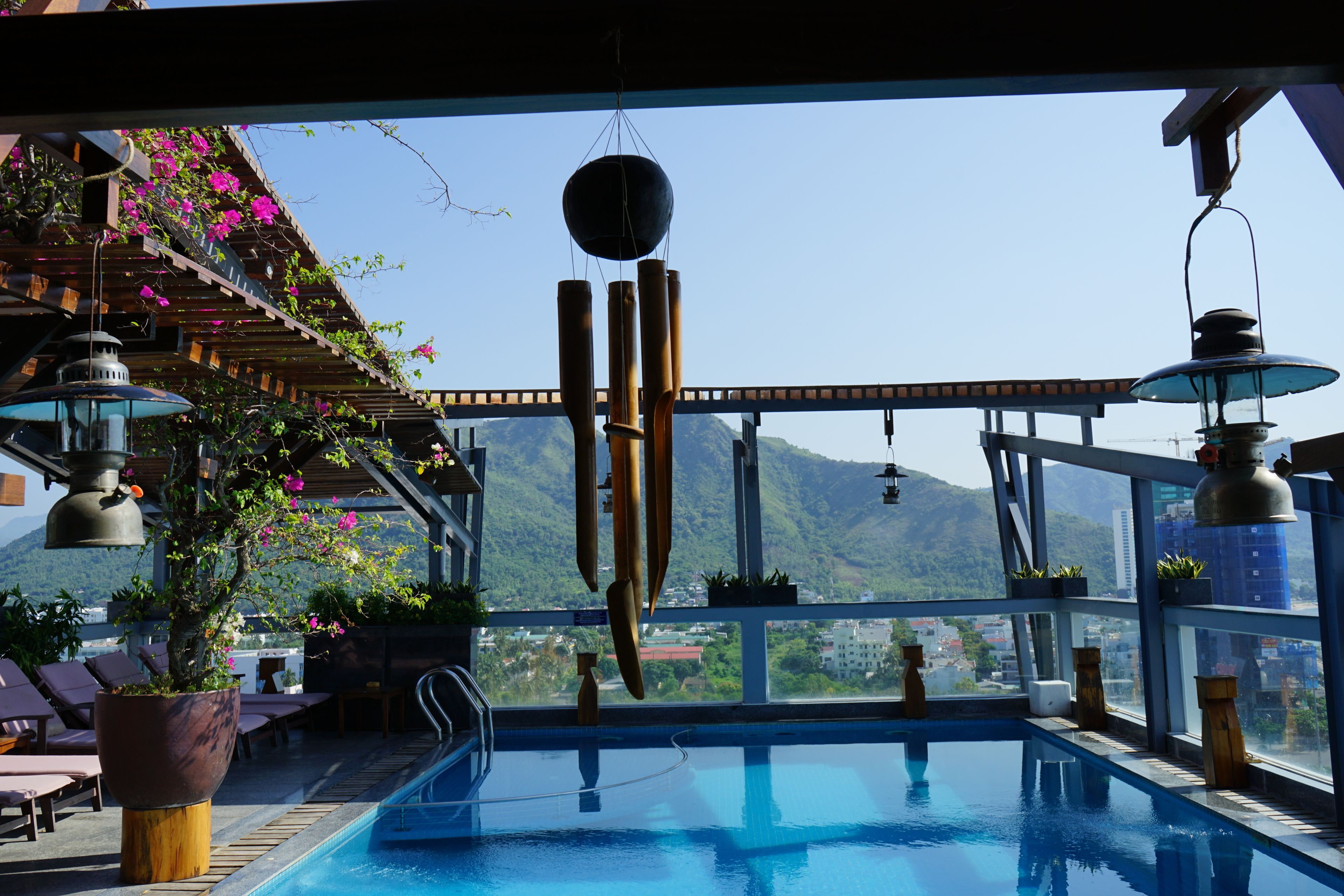 Piscina no terraço com vista desimpedida para montanhas e paisagem urbana.