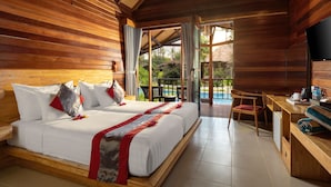 Quarto estilo cabana de madeira com cama, escrivaninha e vista para uma piscina.