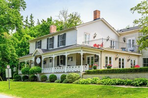 Uma casa de dois andares com varanda, varandas e um jardim.