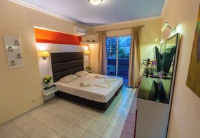 Quarto moderno com cama, luminárias de cabeceira, mesa de apoio, espelho e vista para o exterior.