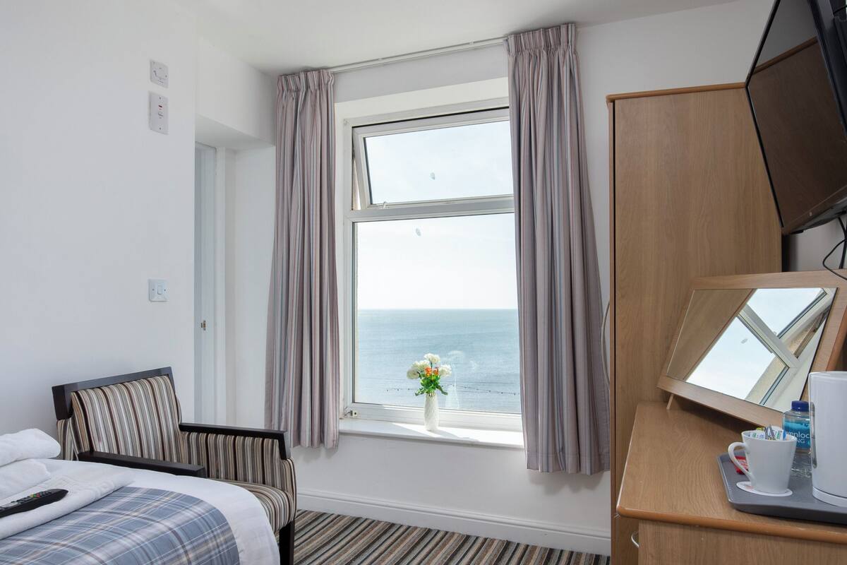 Quarto solteiro, vista para o mar | Escrivaninha, roupa de cama