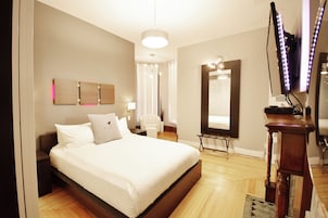 Quarto moderno com uma cama grande, uma toucador com espelho e um lustre.