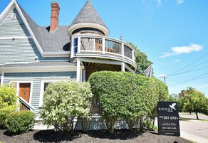 Uma casa em estilo vitoriano com uma torre, varanda e placa indicando Bower de County.