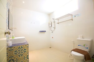 Casa de banho com chuveiro, sanita e lavatório.