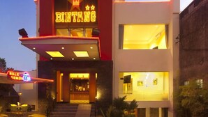 Um hotel moderno com um letreiro de neon chamativo com a palavra "BINTANG" e uma área de recepção visível.
