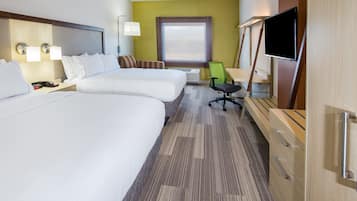Quarto de hotel com duas camas, uma escrivaninha com cadeira, televisão de tela plana e janela com vista.