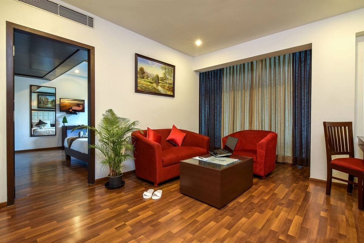 Uma sala de estar moderna com um sofá, poltronas, uma mesa de centro e um vaso de planta.