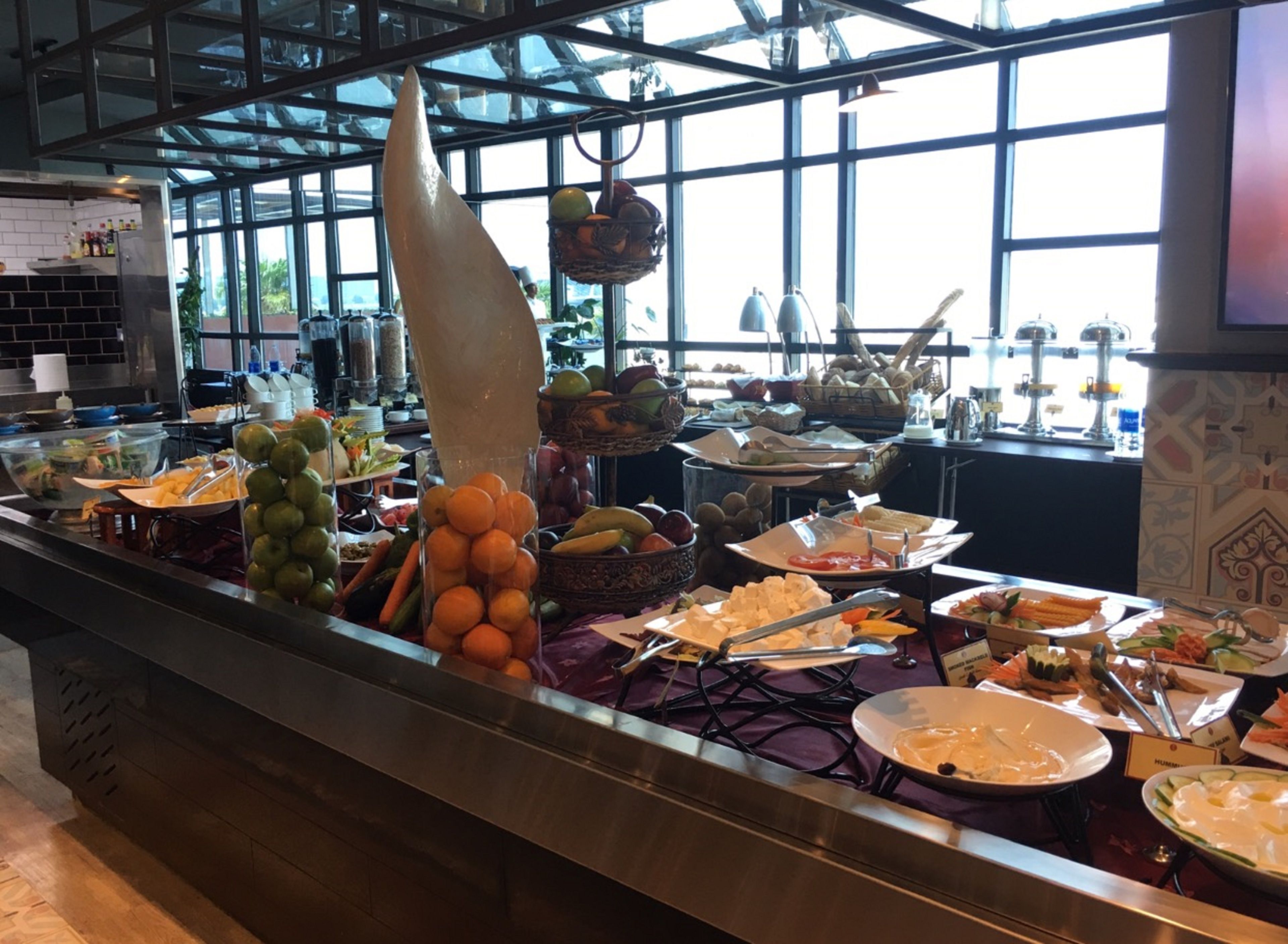 Buffet com diversos alimentos e um grande pão.