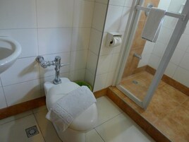 Casa de banho com sanita, lavatório e zona de duche.