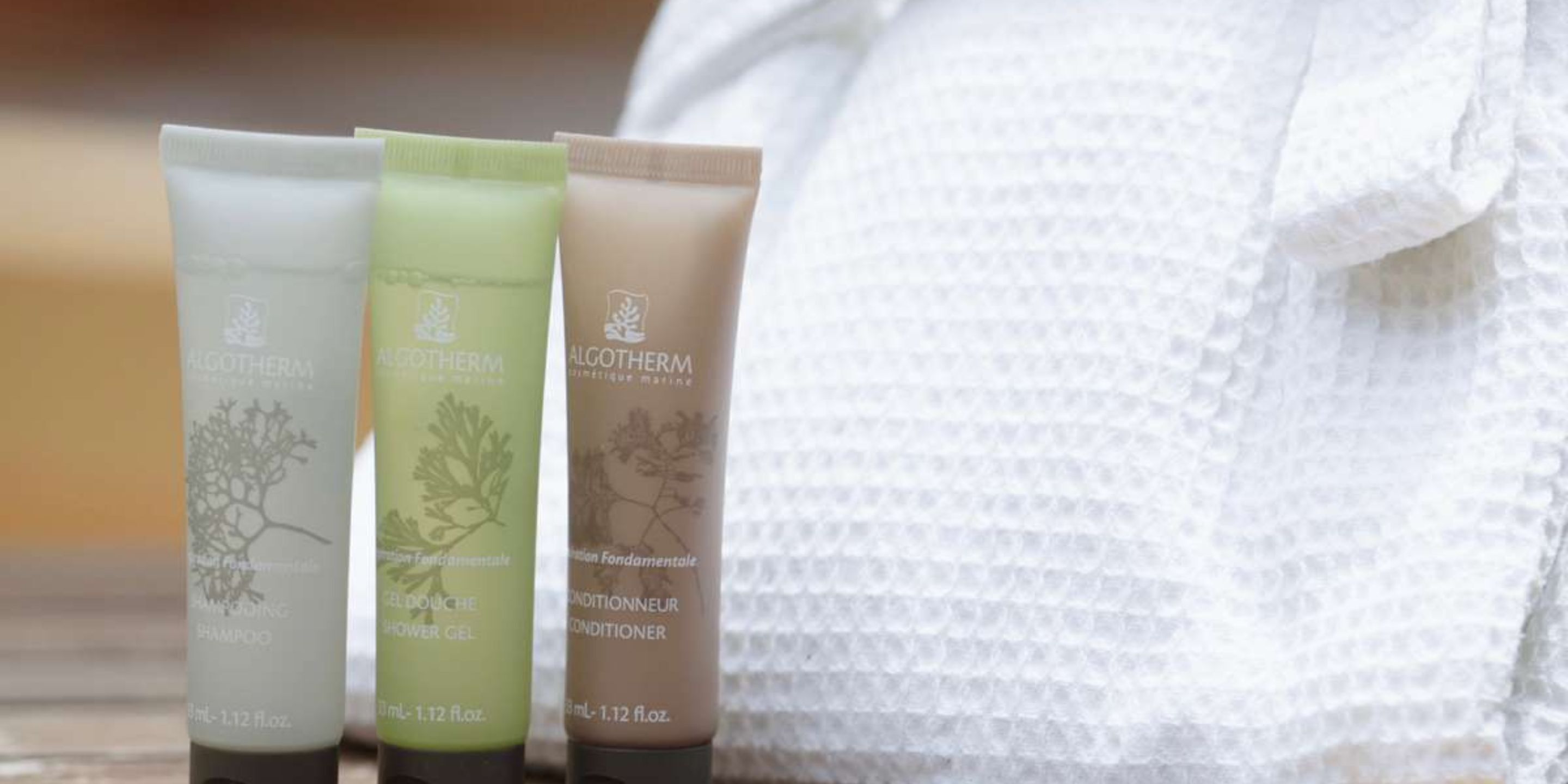 Três produtos de higiene: shampoo, gel de banho e condicionador.
