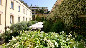 Um beco estreito com edifícios de ambos os lados, alguns com varandas e vegetação.