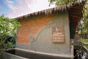 Parede de tijolos com uma placa de madeira para um centro de bem-estar ayurvédico.