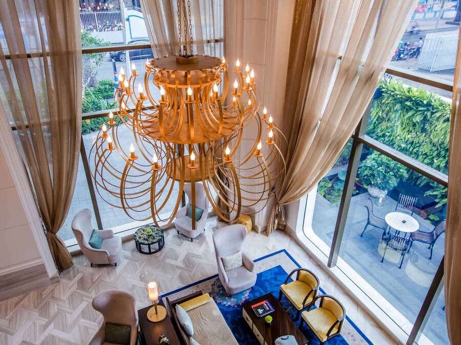 Decoração moderna com um lustre grande, assentos confortáveis e vista para o exterior.