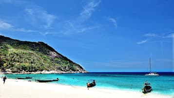 Uma praia privada, toalhas de praia, voleibol de praia