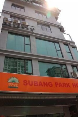 Um edifício com vários andares, com uma placa laranja de destaque que diz 