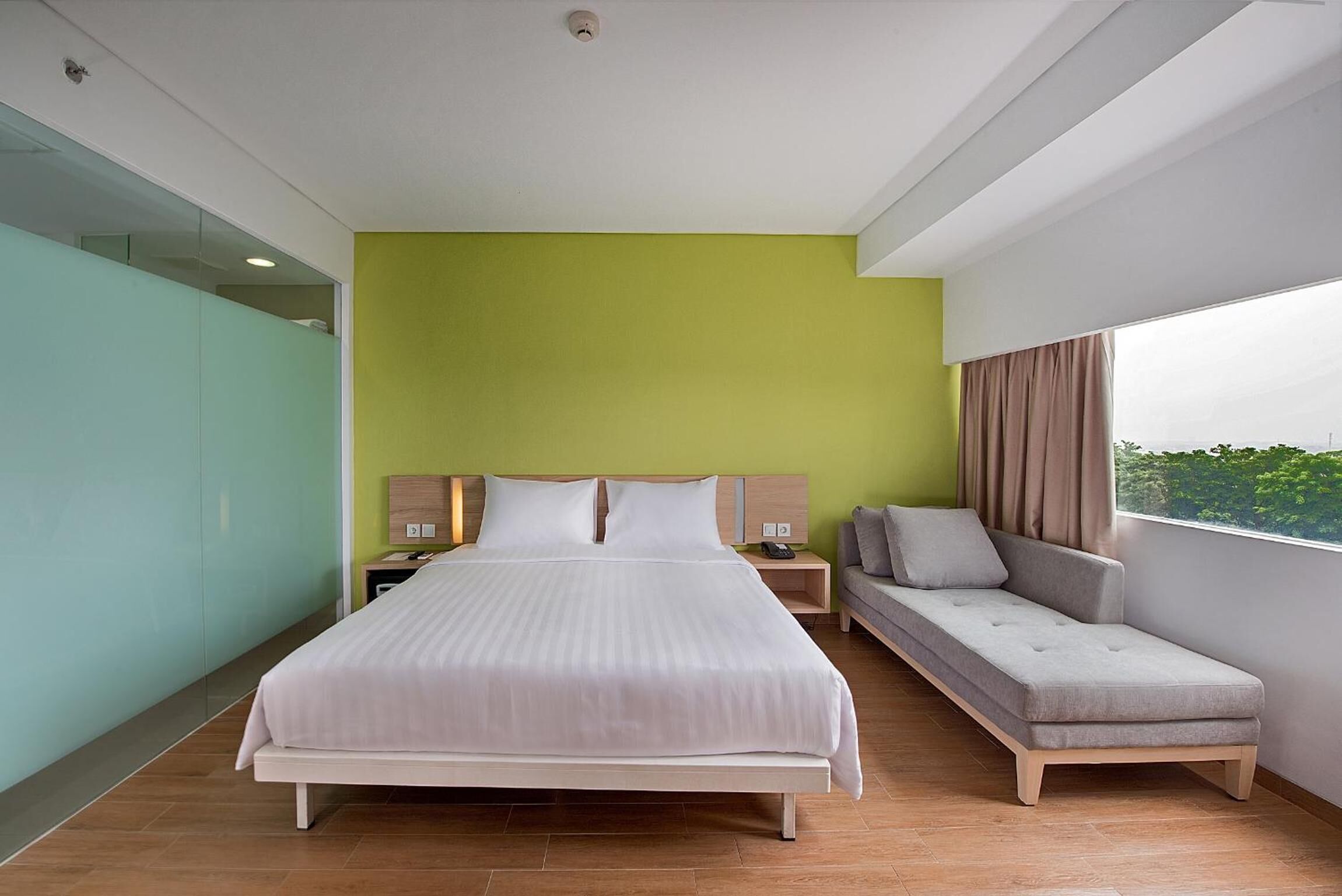 Quarto moderno com uma cama grande, um sofá e uma mesinha de cabeceira.