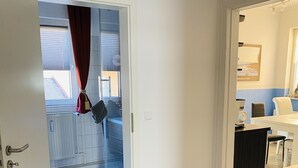 Quarto de hotel moderno com uma cama grande, uma escrivaninha pequena e vista para a cidade.