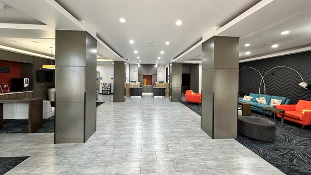 Um hall amplo com balcão de recepção, área de estar e design moderno.