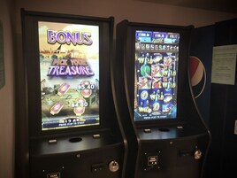 Duas máquinas de jogo com telas exibindo diferentes jogos, uma rotulada 'BONUS' e outra 'Plunder Pirates'.