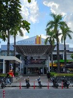 Um edifício com uma placa que diz "CENANG MALL" e uma placa com "ONE LOVE" logo abaixo.