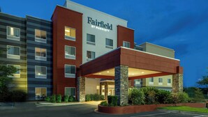 Um hotel Fairfield by Marriott com design moderno, apresentando uma entrada marcante e um estacionamento.