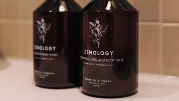 Dois frascos de bálsamo para as mãos e corpo Zenology sobre uma superfície branca.