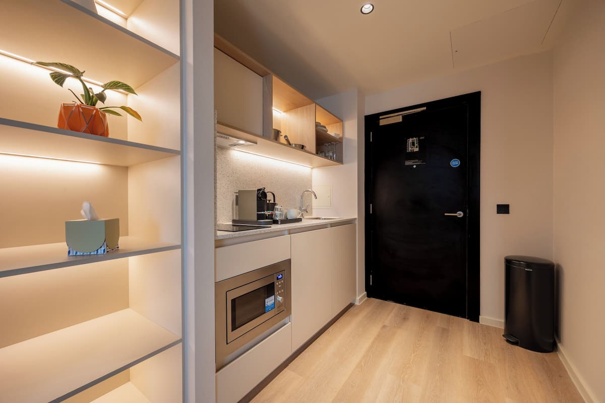 Uma cozinha moderna com eletrodomésticos embutidos, uma porta preta e uma lixeira.