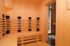 Uma sauna de madeira com bancos e painéis de ventilação.