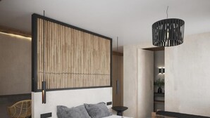 Quarto moderno com cama grande, cabeceira de bambu, mesinha de cabeceira redonda preta e luminária suspensa.
