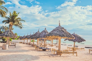 Na praia, espreguiçadeiras, guarda-sóis de praia, toalhas de praia