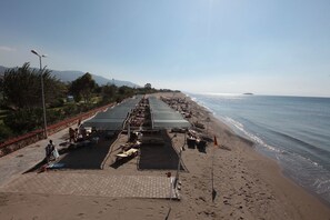 Praia particular, espreguiçadeiras, guarda-sóis 