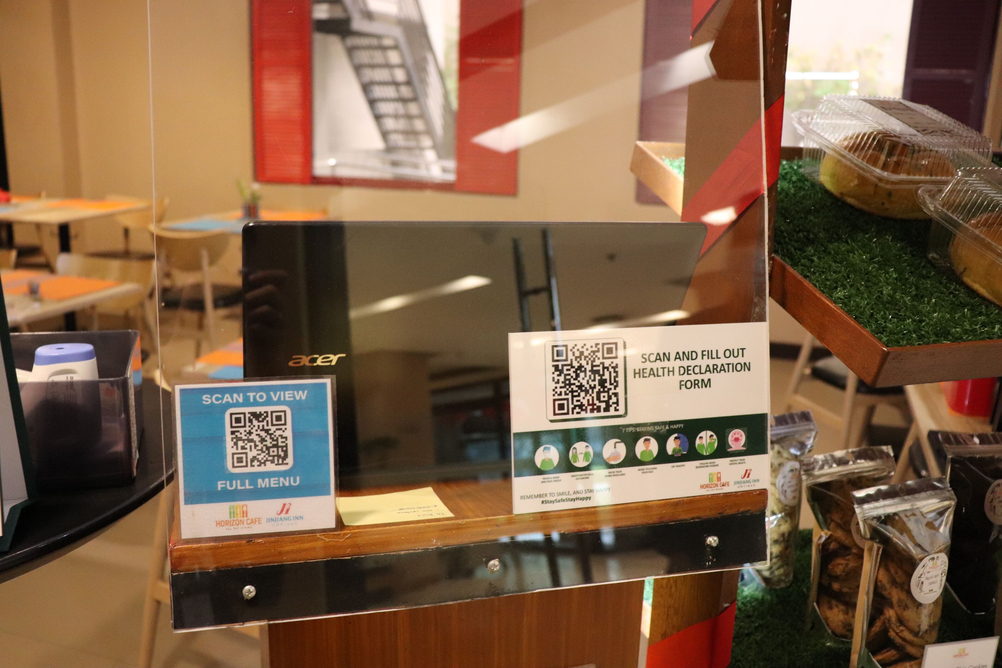 Um balcão com código QR para o menu e formulário de declaração de saúde.
