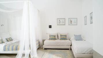 Quarto com cama, sofá, mesa de cabeceira e prateleira na parede.